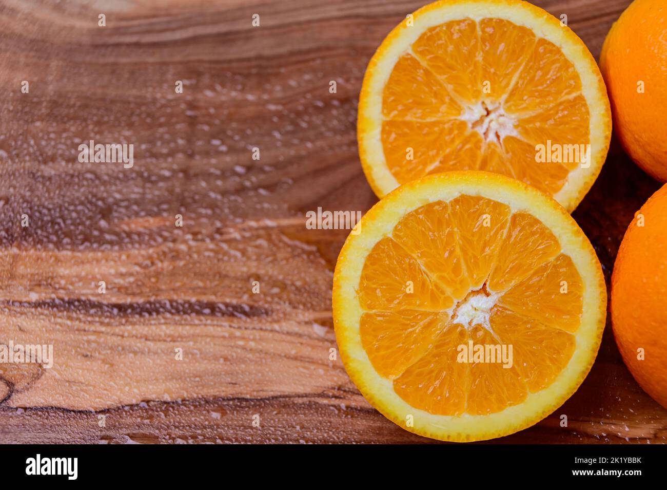 Whole and sliced Oranges on a wooden background with room for wording ...