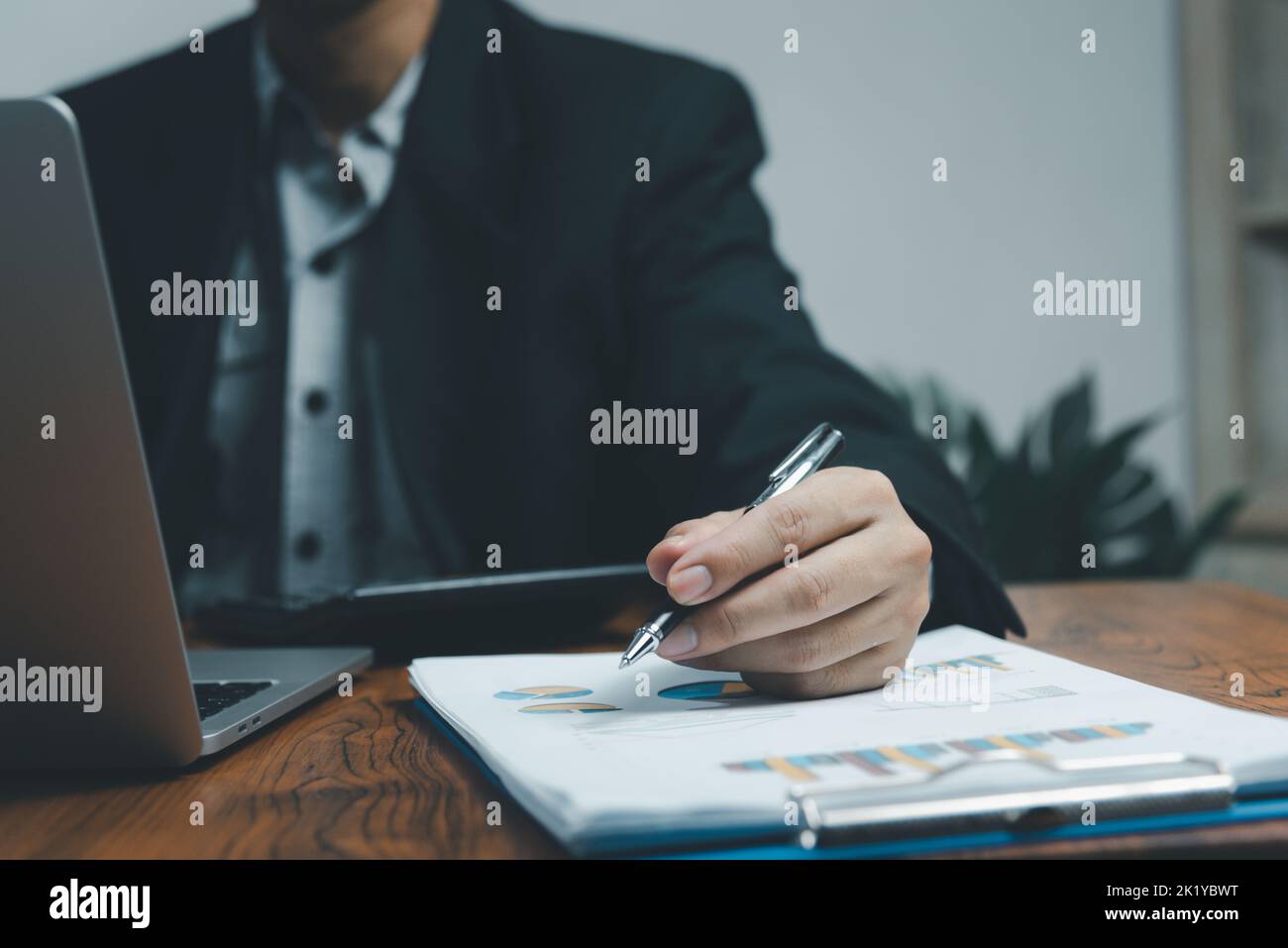 Businessman hand holding pen pointing paperwork chart report analysis ...