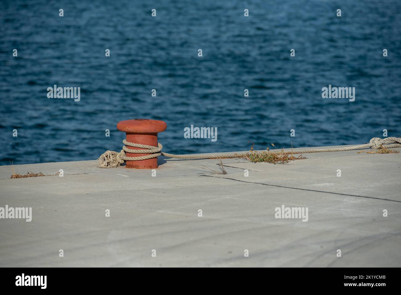 A red orange mooring bollard at a port dock Stock Photo - Alamy