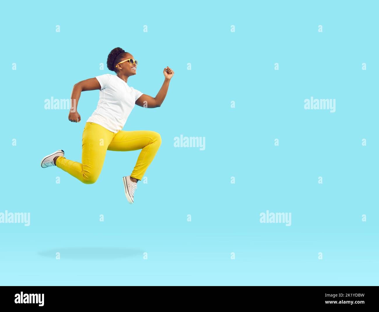 Happy woman running, flying or jumping high in air isolated on blue ...