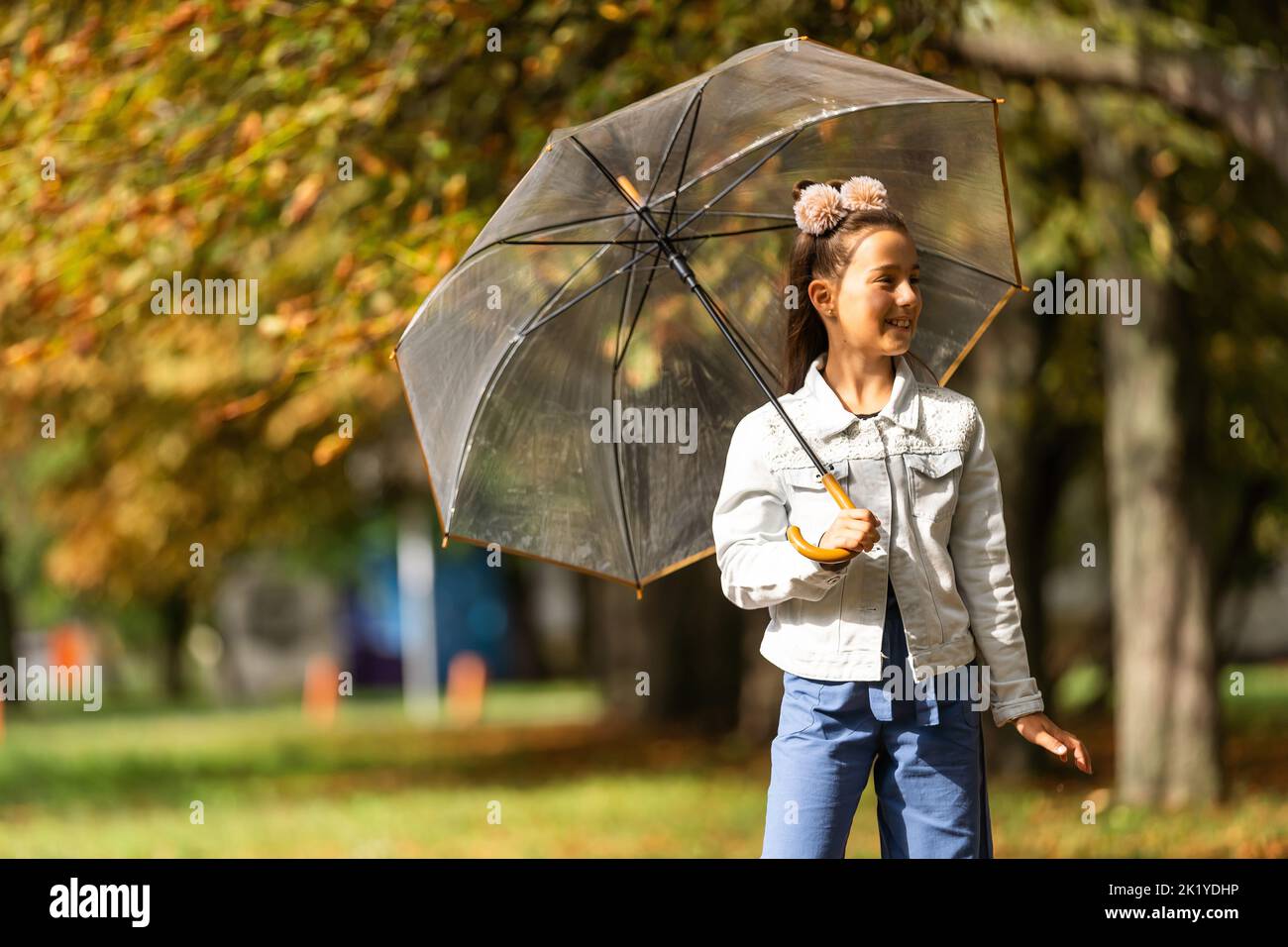 Kid playing out in the rain. Children with umbrella play outdoors in ...