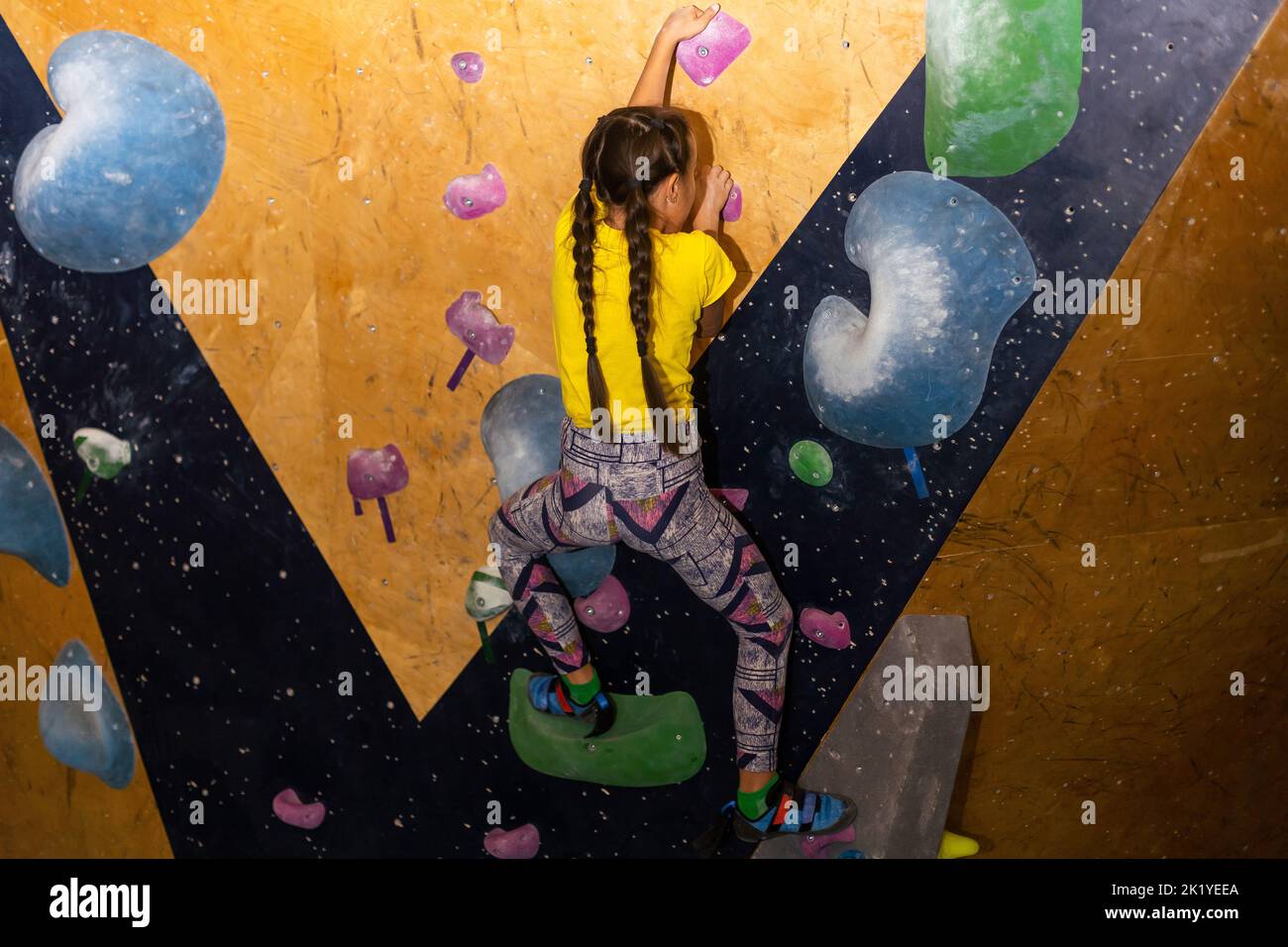 little girl climbing a rock wall indoor Stock Photo - Alamy
