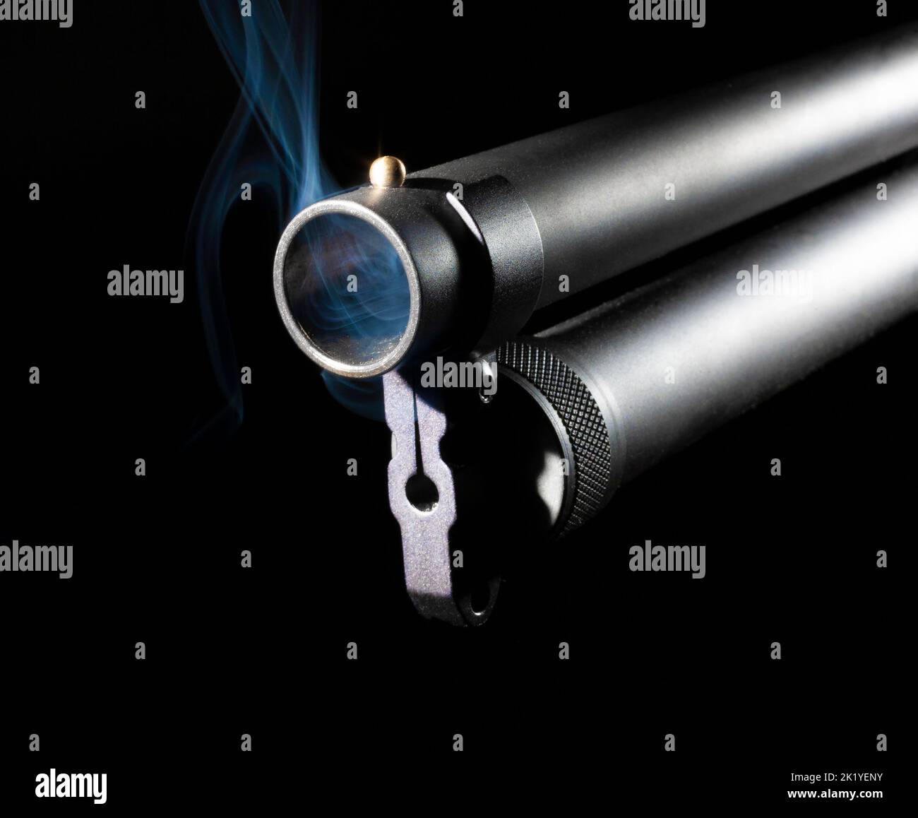 Shotgun barrel that has blue smoke coming out on a black background ...