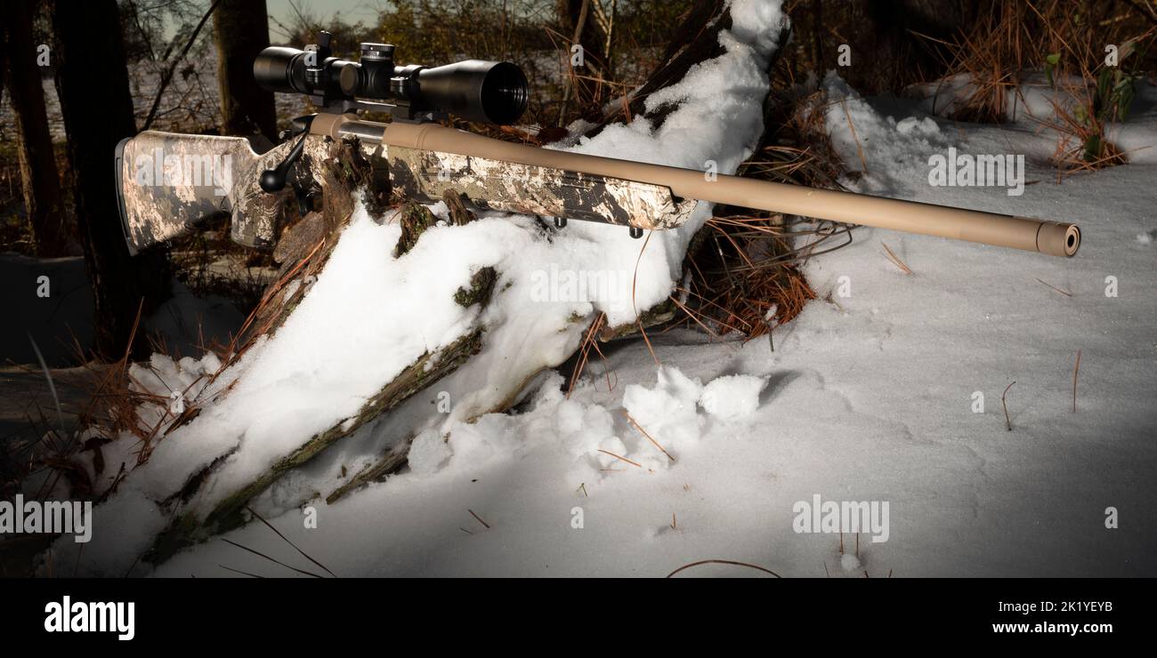 Bolt action rifle with rifle scope in a winter forest with copy space ...