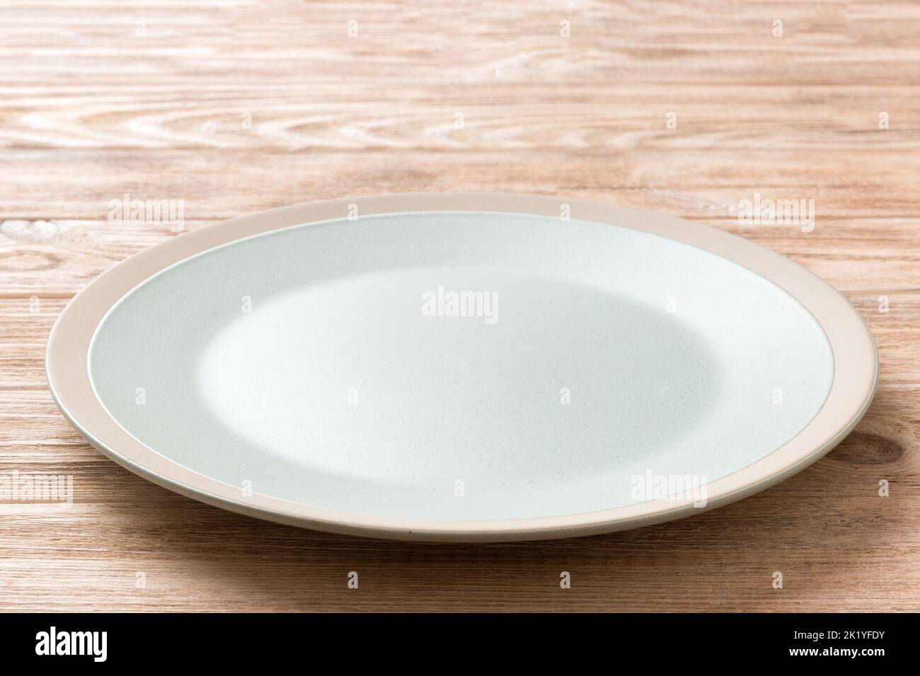 Perspective view of empty light plate on wooden background. Empty space ...
