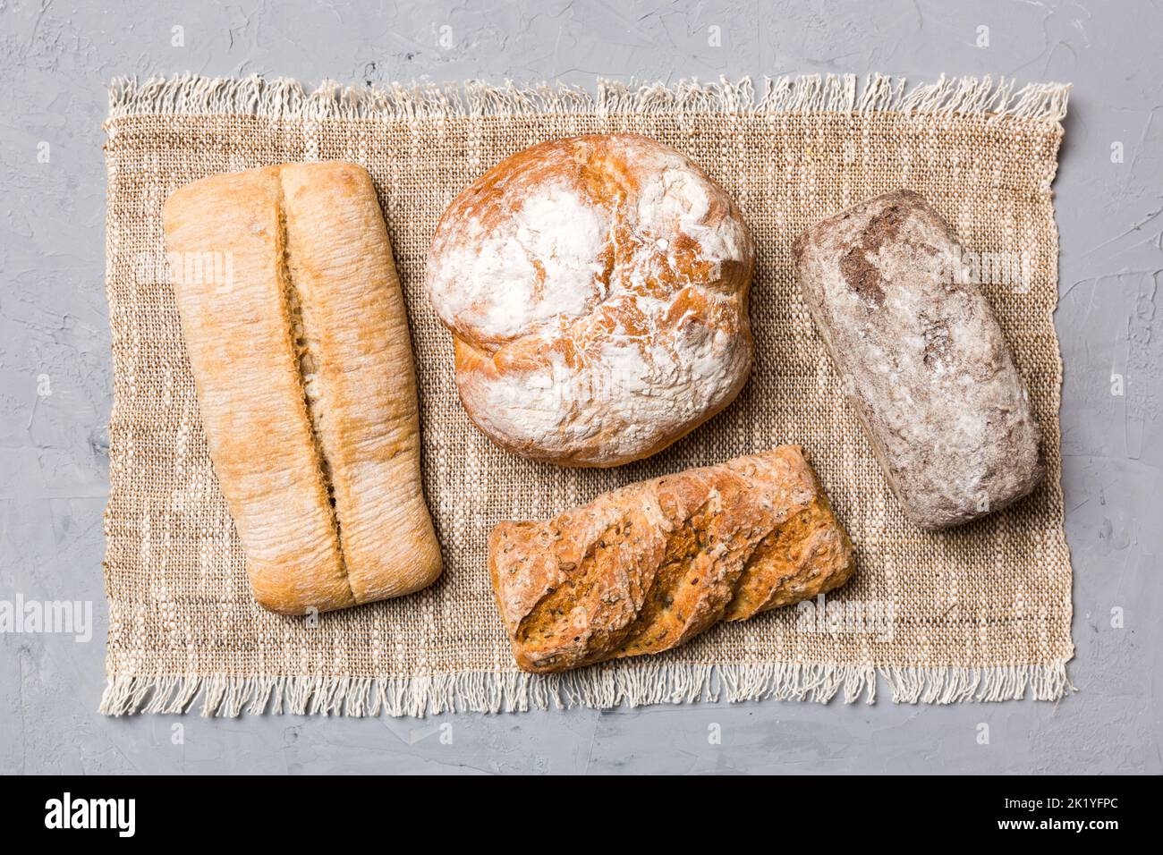 Assortment of freshly baked bread with napkin on rustic table top view ...