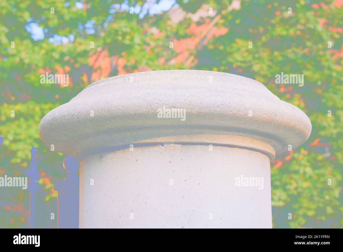 The top of a round column standing in the garden in a colorful faded ...