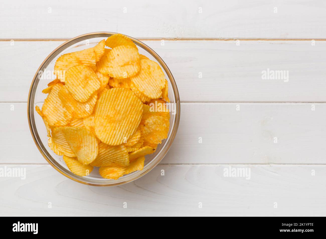Potato chips on bowl isolated on colored background. Delicious crispy ...