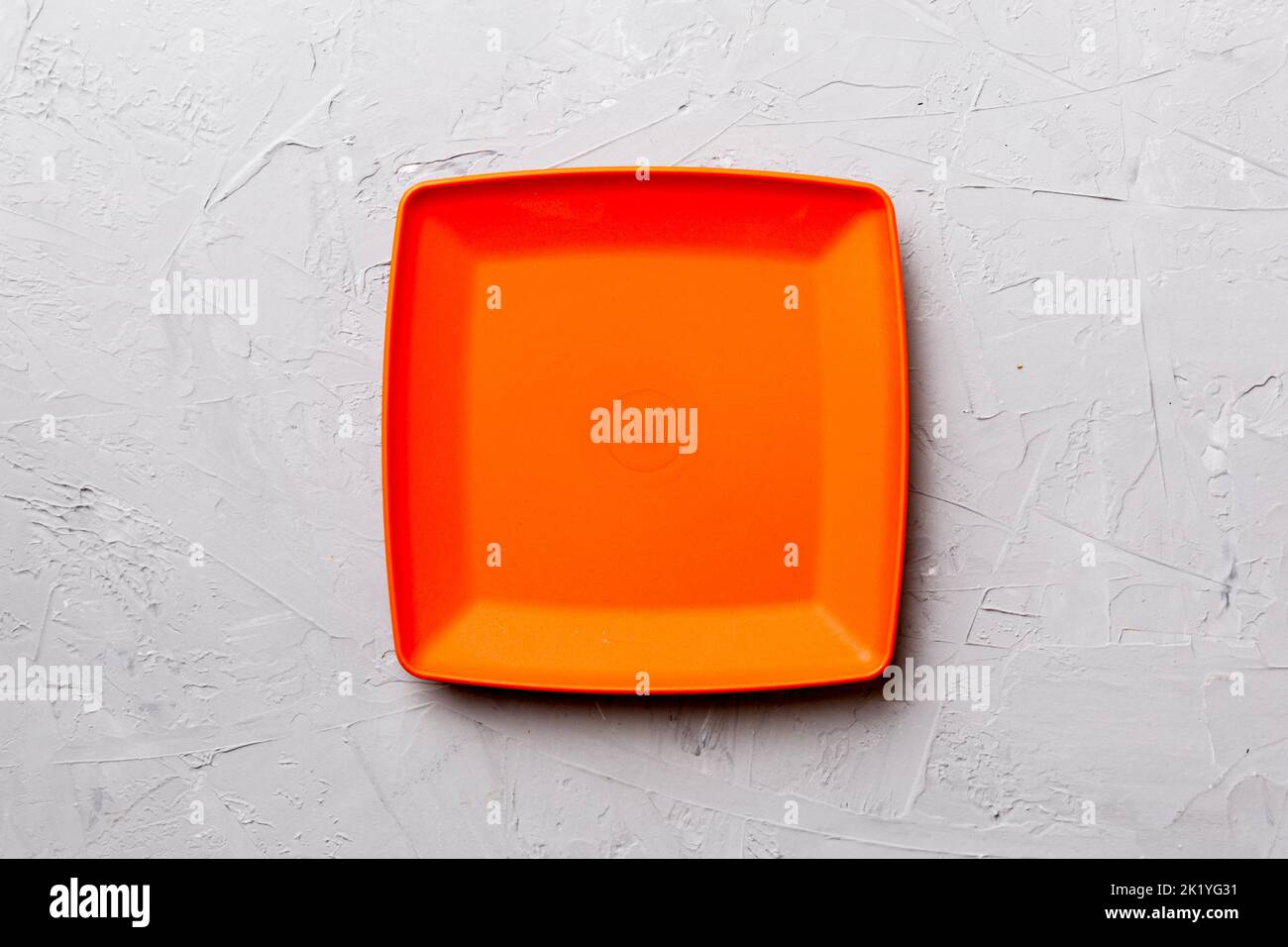 Top view of empty square plate on cement background. Empty space for ...