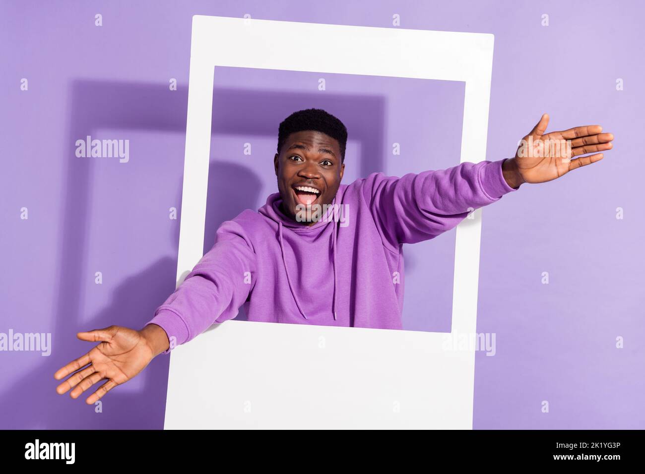 Portrait of positive funky person raise arms through paper album card ...