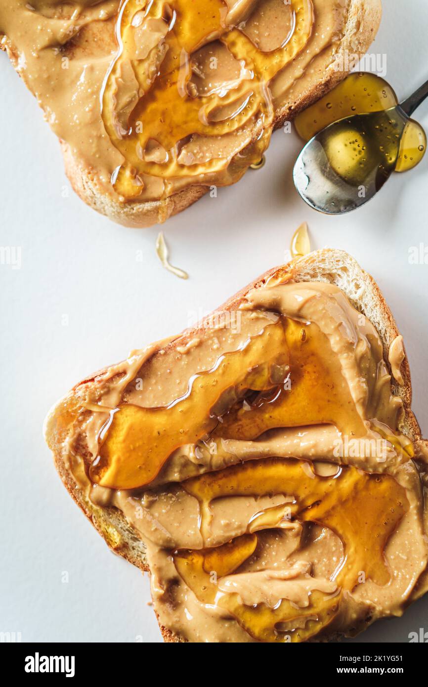 A top view of two pieces of toast with peanut butter and honey spread ...
