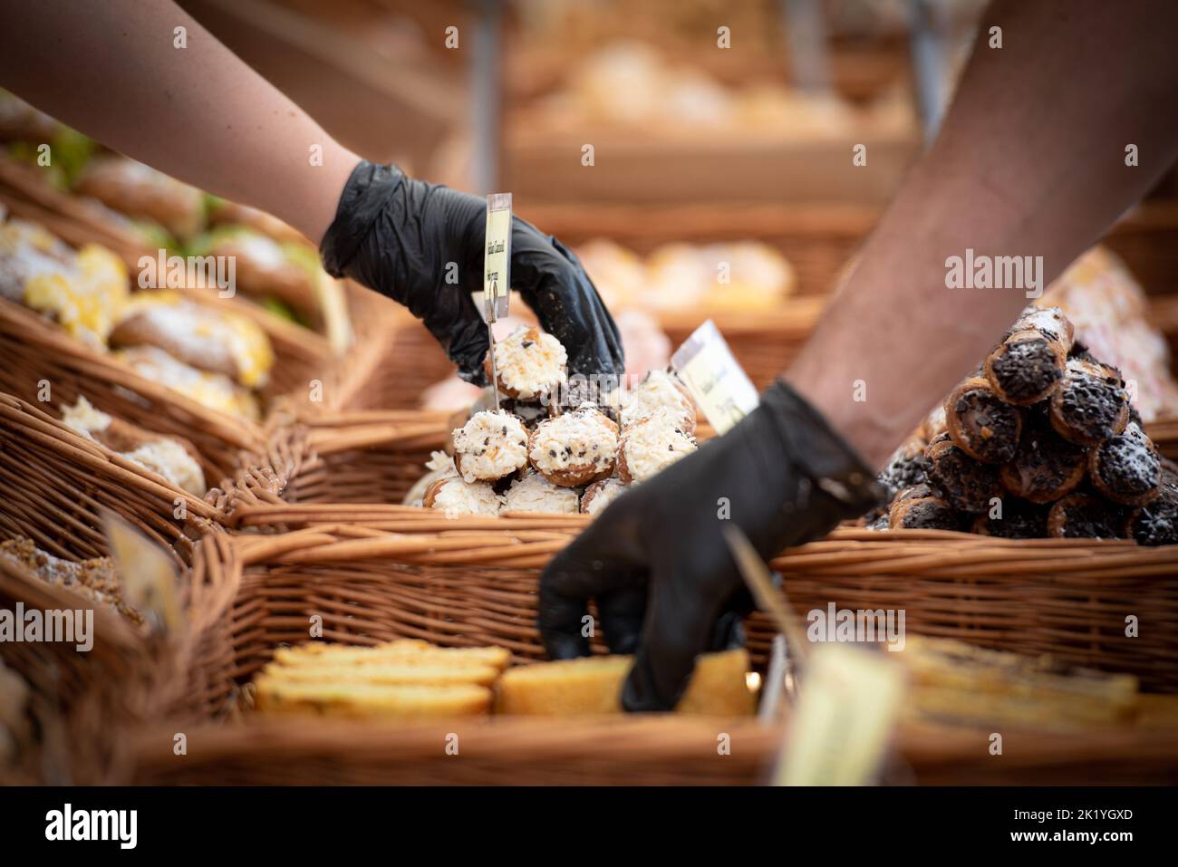 The hands picking different pastries in the straw baskets in the food ...