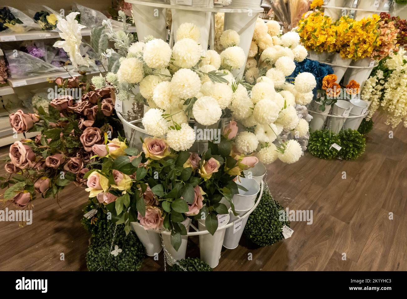 A variety of colourful plastic synthetic flowers in a budget shop in ...