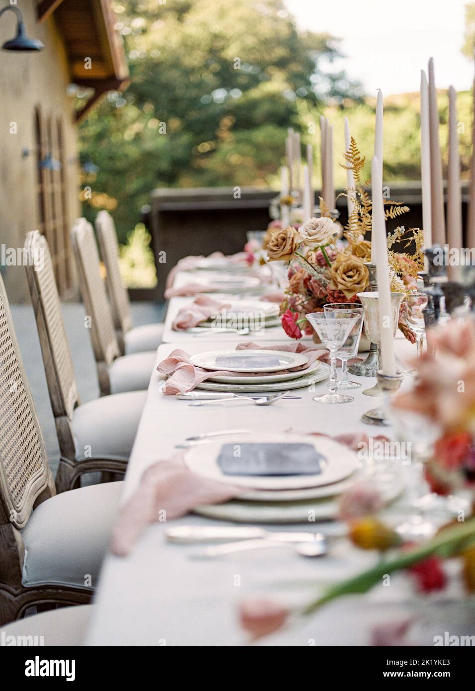 A shallow focus shot of reception table with white ceramic dishes and ...