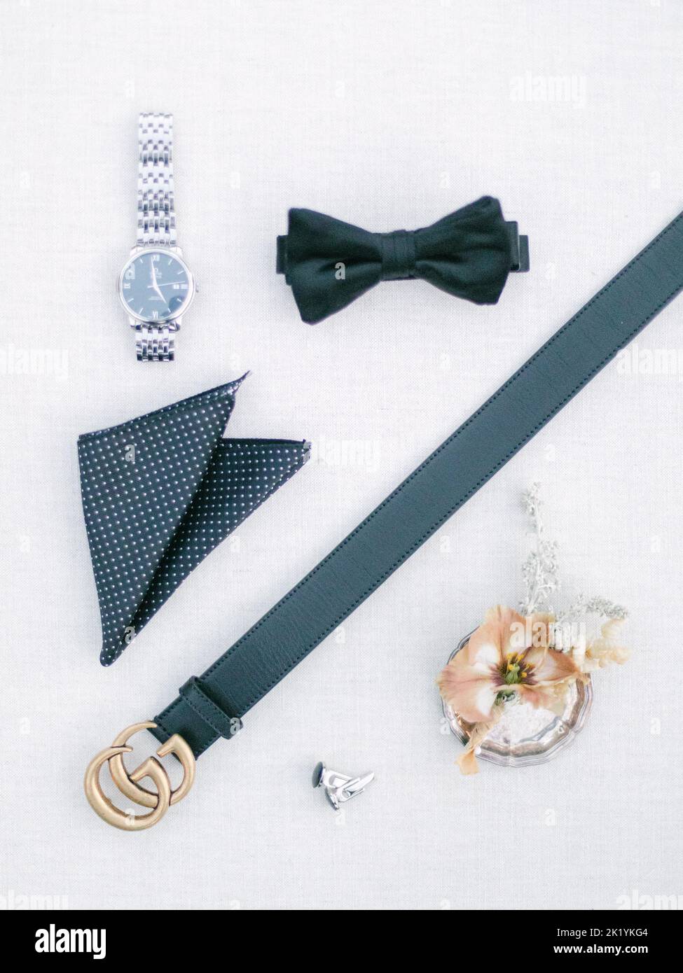 A top view shot of black Leather belt, black bow, watch and pocket ...