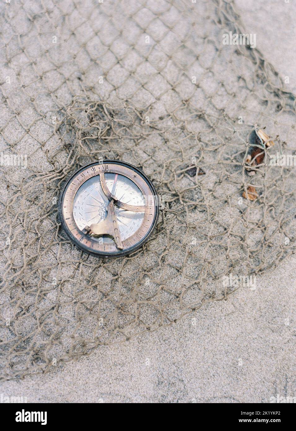A top view shot of an old metal compass on net mesh surface Stock Photo ...