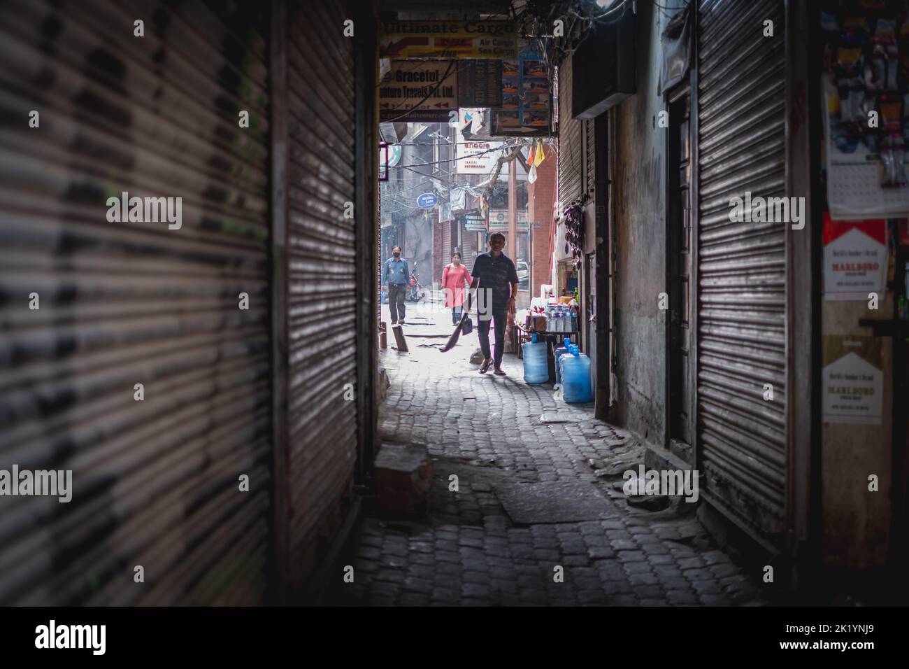 A man walking down an alleyway into the sun in Kathmandu Stock Photo ...