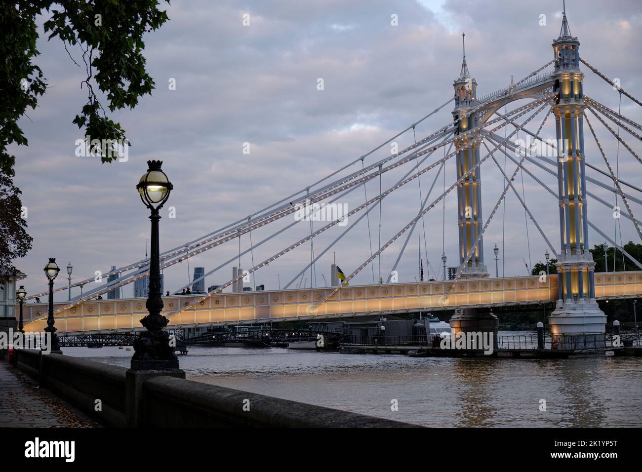 View of Albert Bridge from north side of River Thames in London at dusk ...