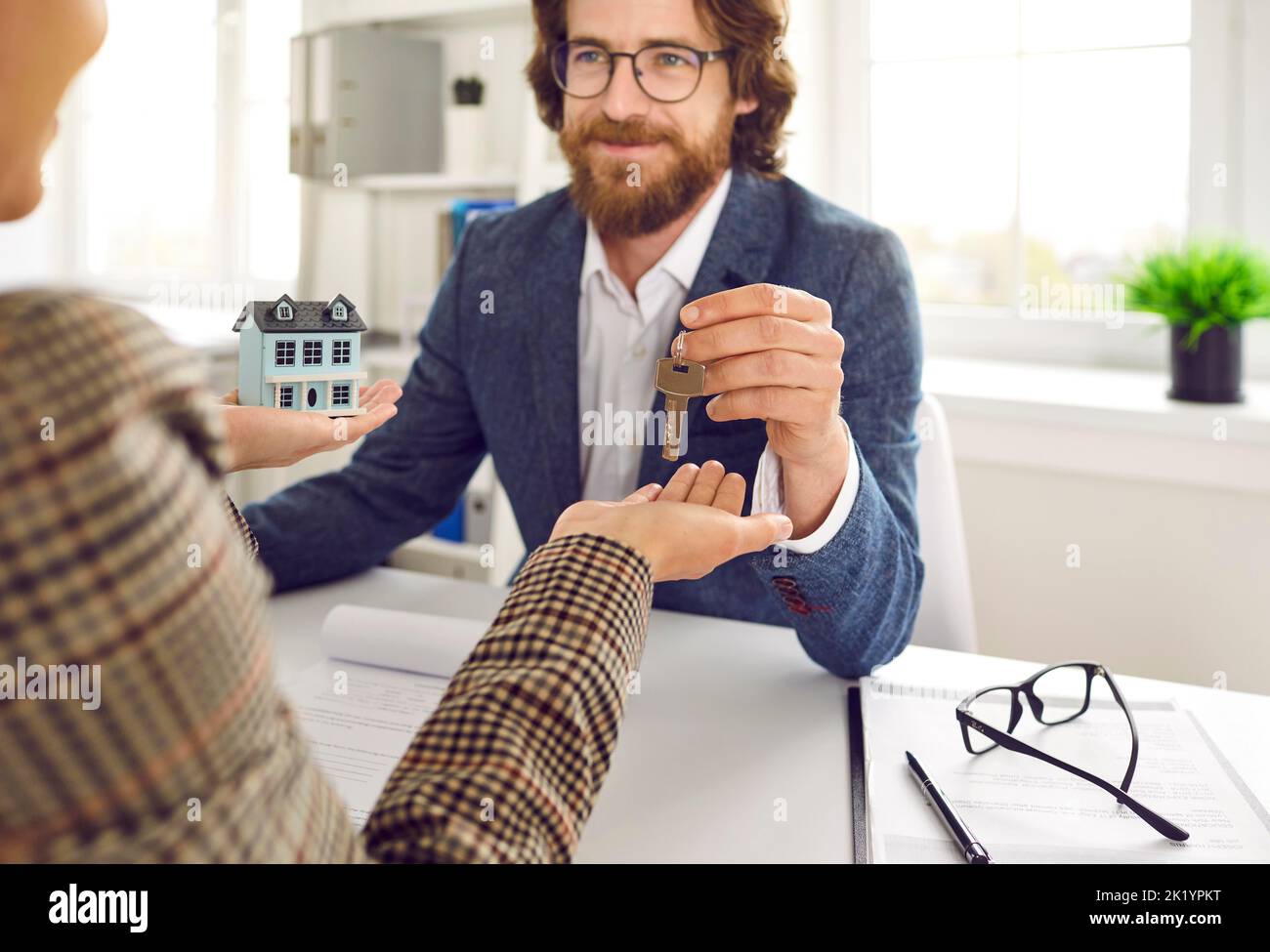 Friendly male real estate agent gives keys to new house to woman who ...