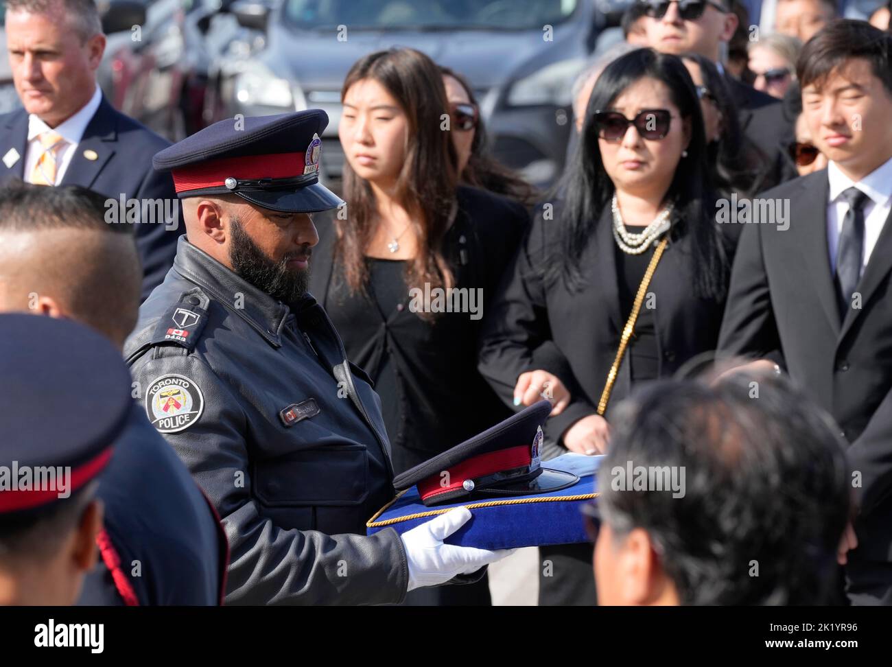 Const. Andrew Hong's police hat is carried past his family, wife Jenny ...
