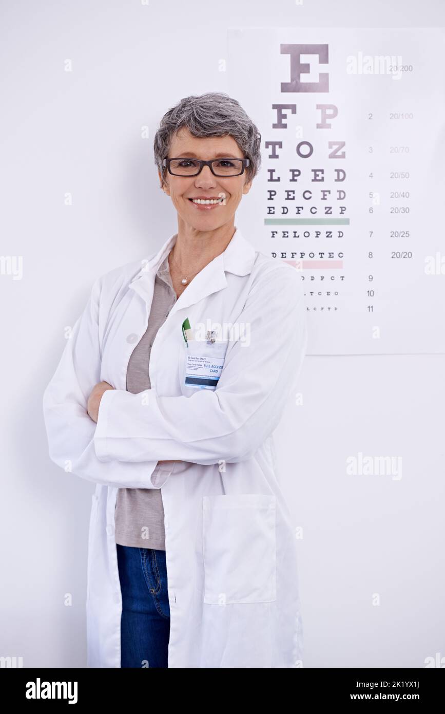 Time for an eye test. Portrait of a female optometrist standing beside ...