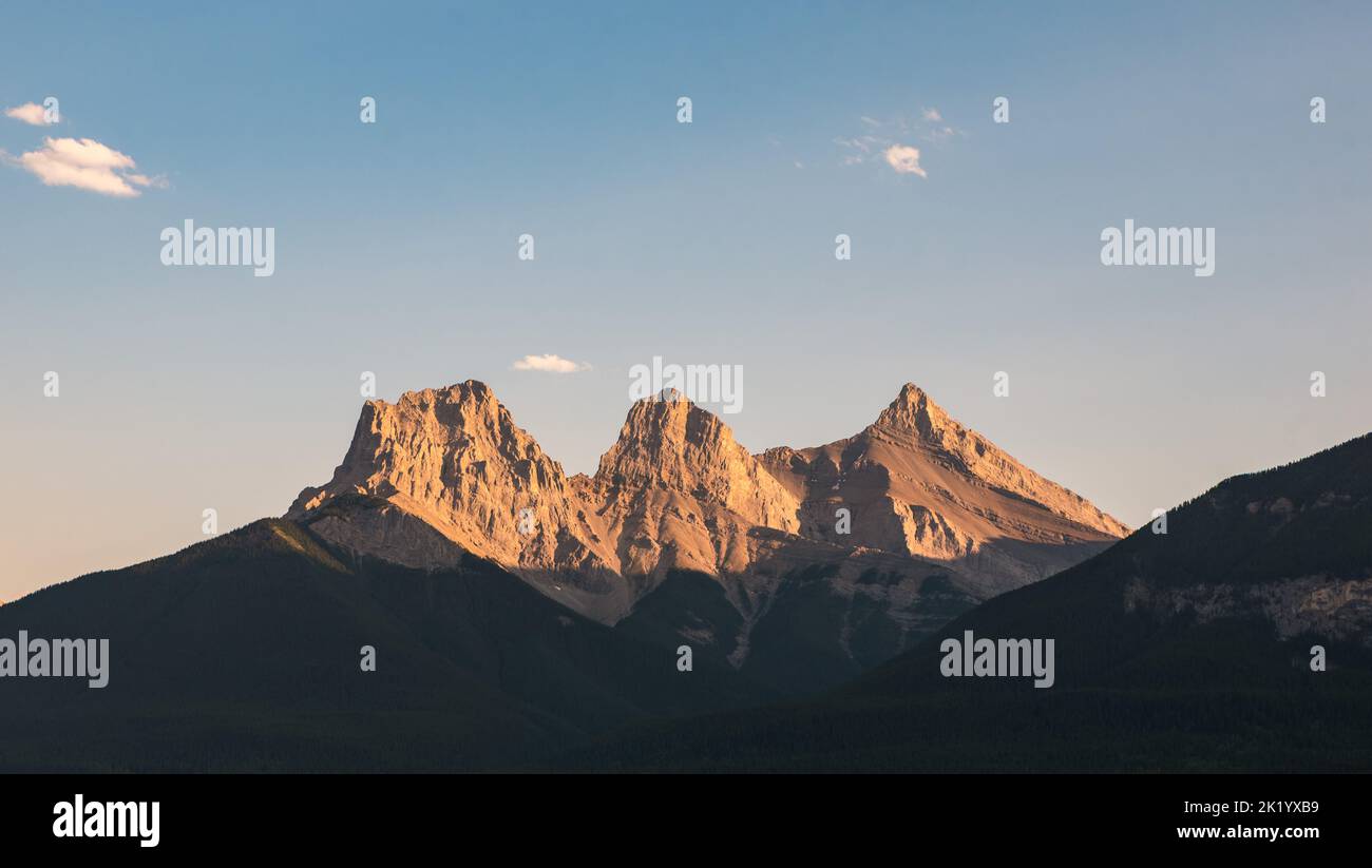 Sun shining on Three Sisters Mountains in Banff National Park, Canada Stock Photo - Alamy