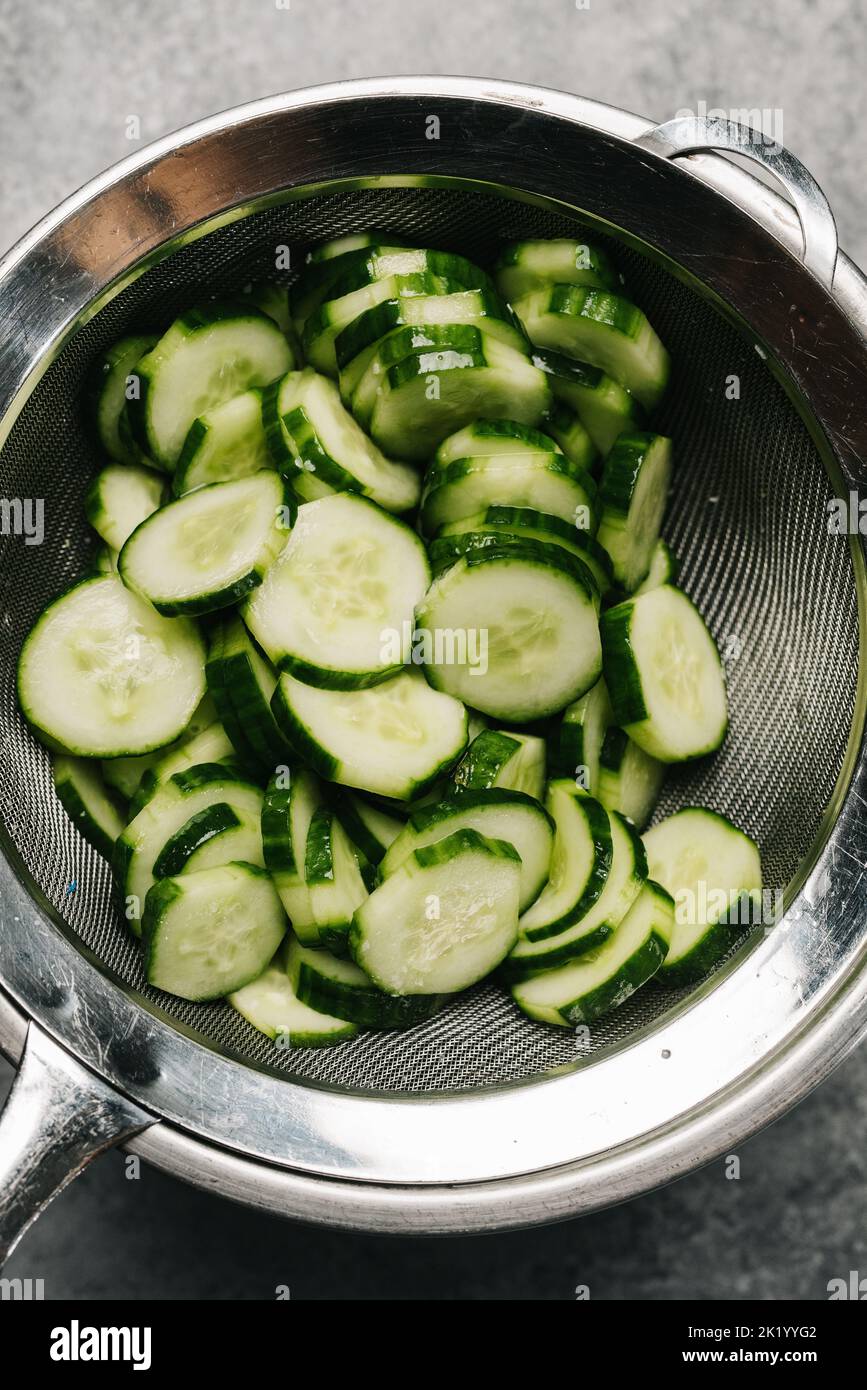 Straining excess liquid from cucumbers Stock Photo - Alamy