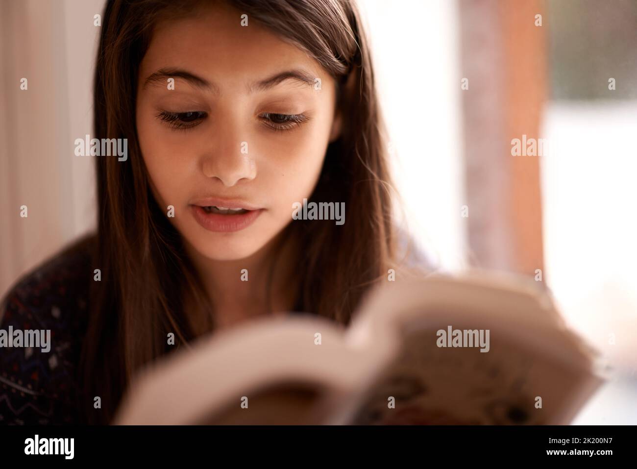 Reading is dreaming with your eyes open. a little girl reading a book ...