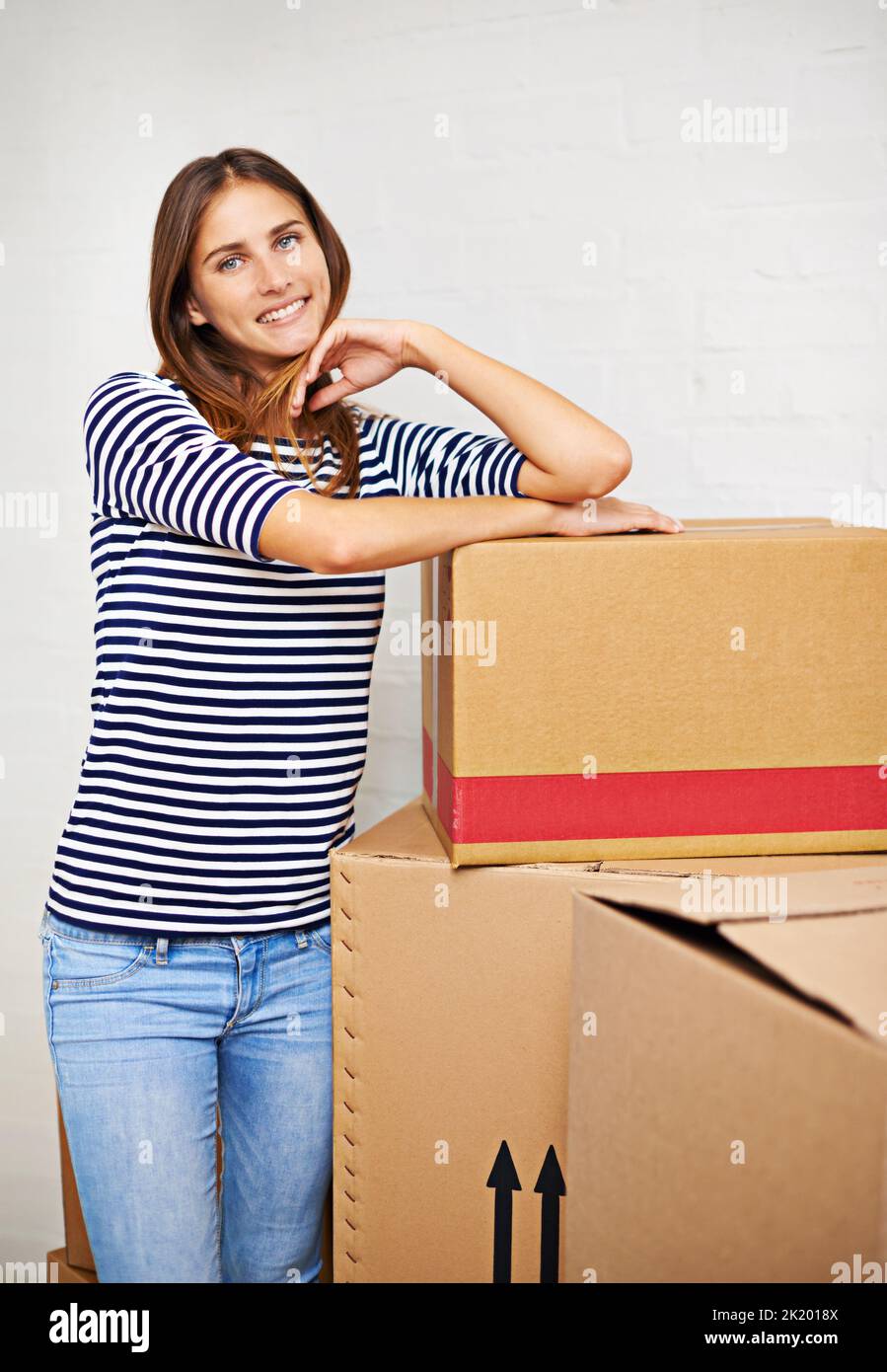 Ready to begin my new life here. an attractive young woman busy moving ...