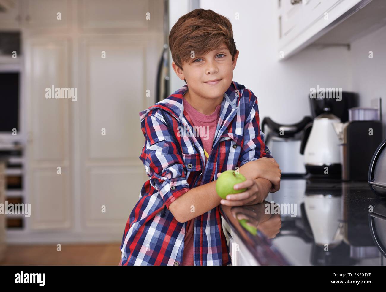 Looking forward to eating this crispy green apple. a young boy leaning ...