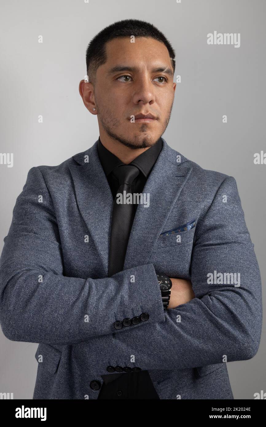 posing with crossed arms a young latin man with short hair wears a suit ...