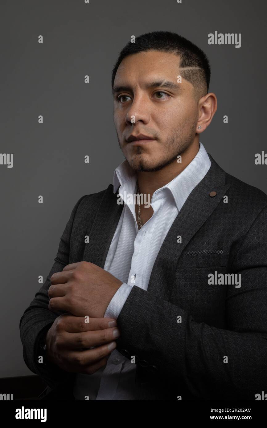 attractive latin young man with short hair holding the sleeve of his ...