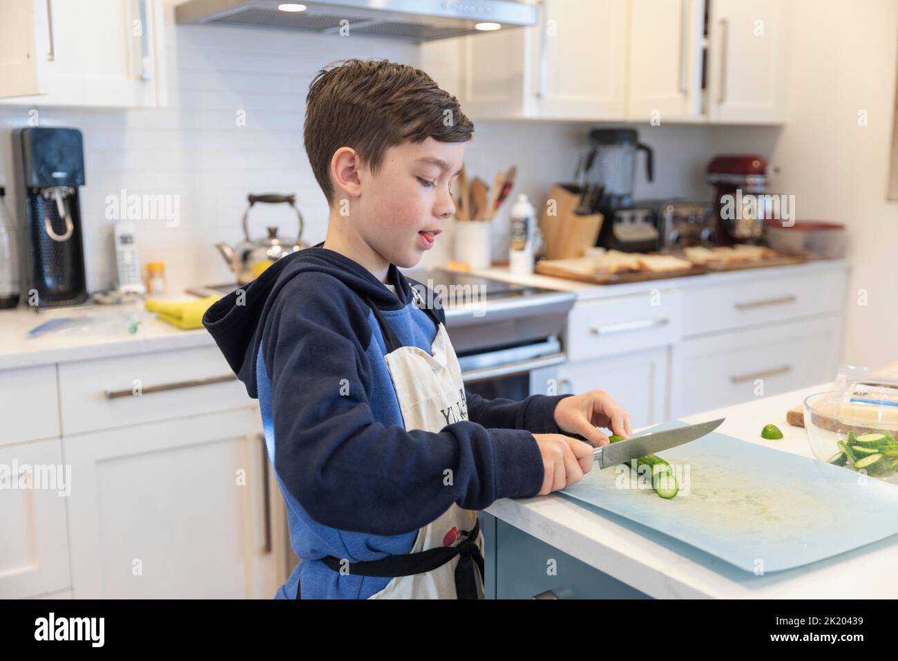 Boy eating cucumber in kitchen hi-res stock photography and images - Alamy