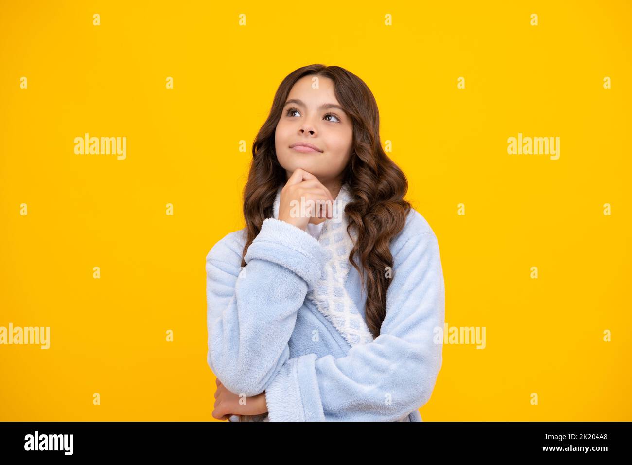 Thoughtful teenage child girl on yellow background. Portrait of a kid ...
