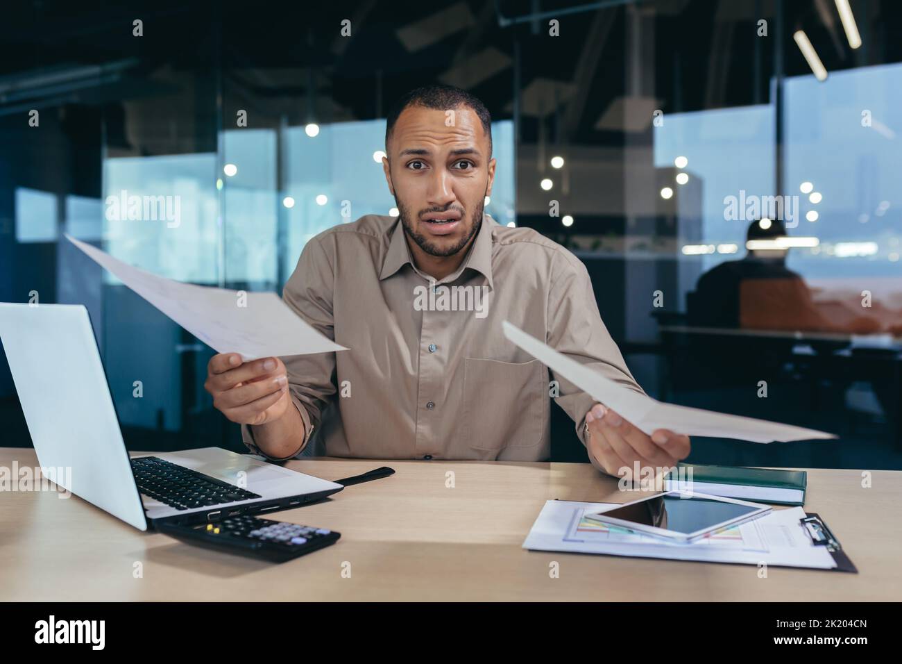 Portrait of disappointed young hispanic financier, businessman looking ...