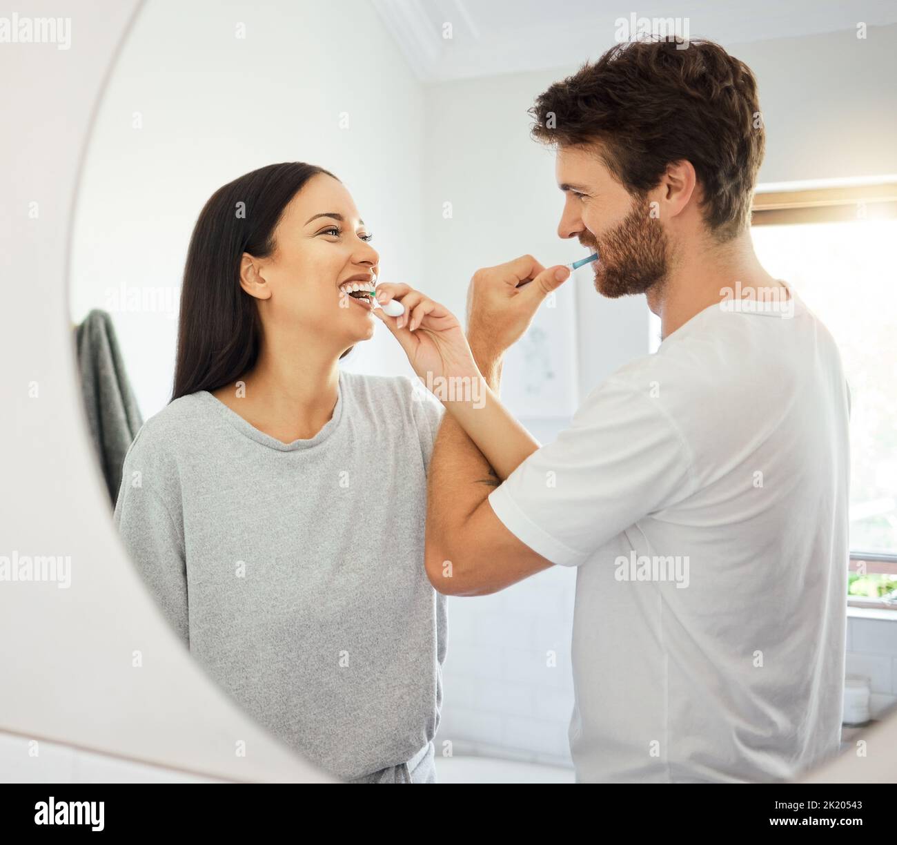 Couple health, dental cleaning and interracial people in bathroom ...
