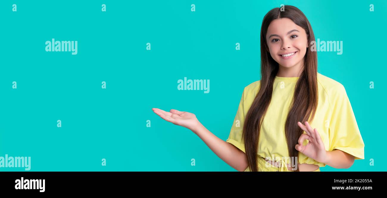 happy child presenting product with ok gesture on blue background with ...