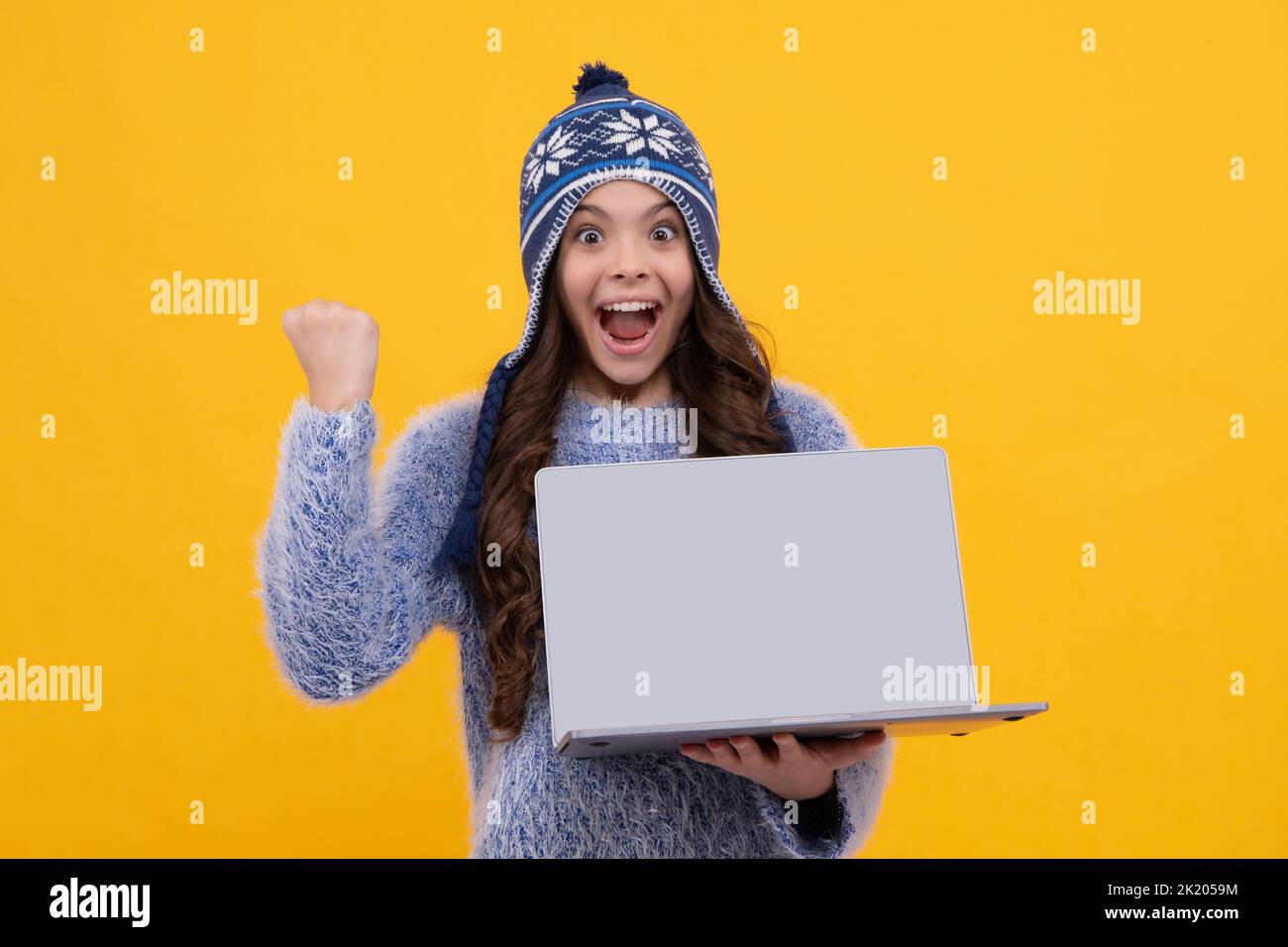 Schoolgirl child student in warn hat hold laptop, isolated yellow ...