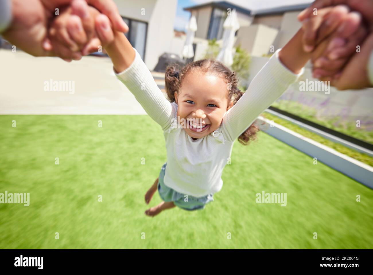 Happy, motion and child spinning on arms of parent in backyard garden ...