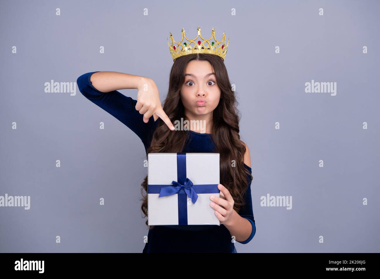 Teenager kid princess in crown with present box. Teen girl giving ...