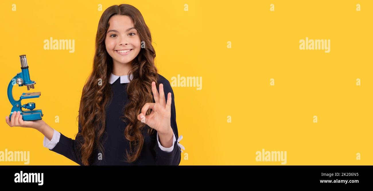 science and childhood. teen girl presenting microscope. Portrait of ...