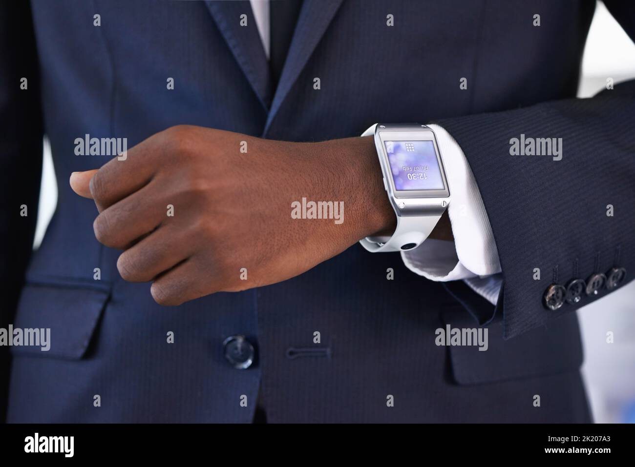 Keeping the time just got hi tech. Cropped view of a young businessman ...