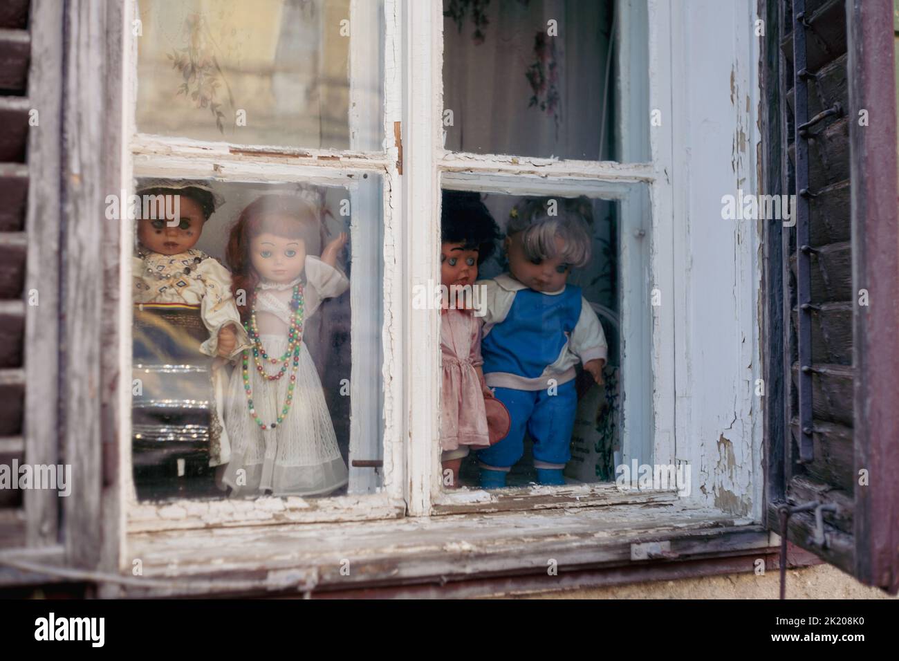 A creepy shot of dolls behind an old window Stock Photo - Alamy