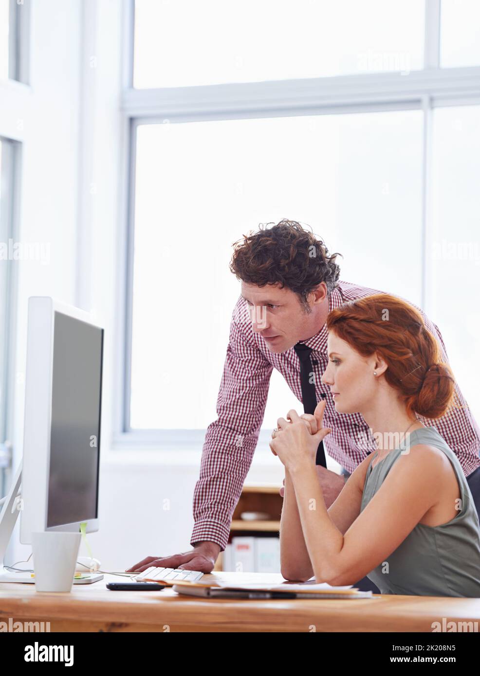 Racking their brains on this project. two business professionals ...