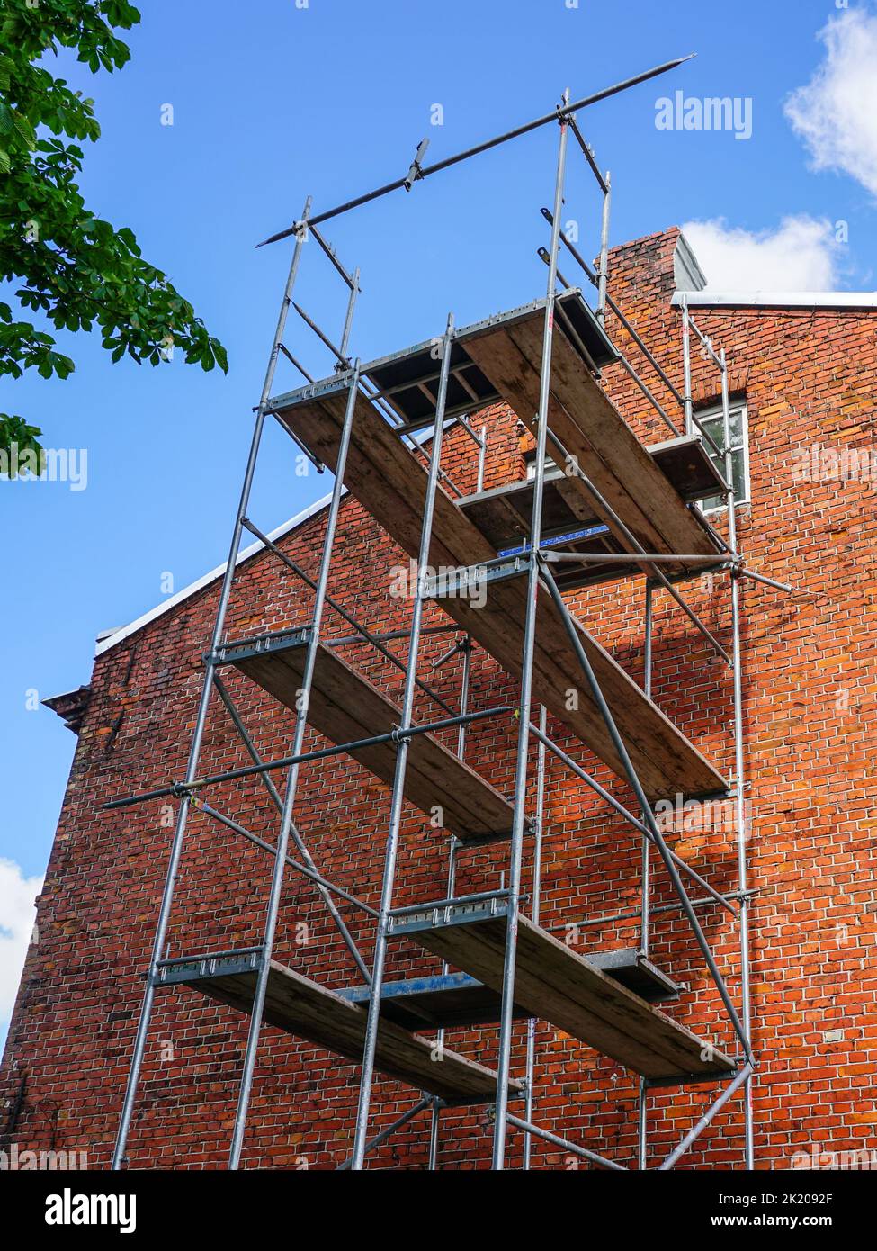 High scaffolding near the wall of a old red brick house for facade ...