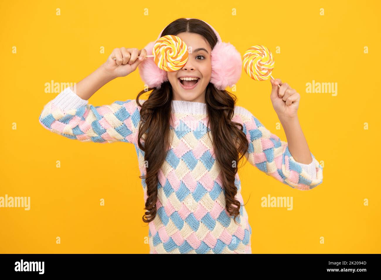 Cool teen child with lollipop over yellow isolated background. Sweet ...
