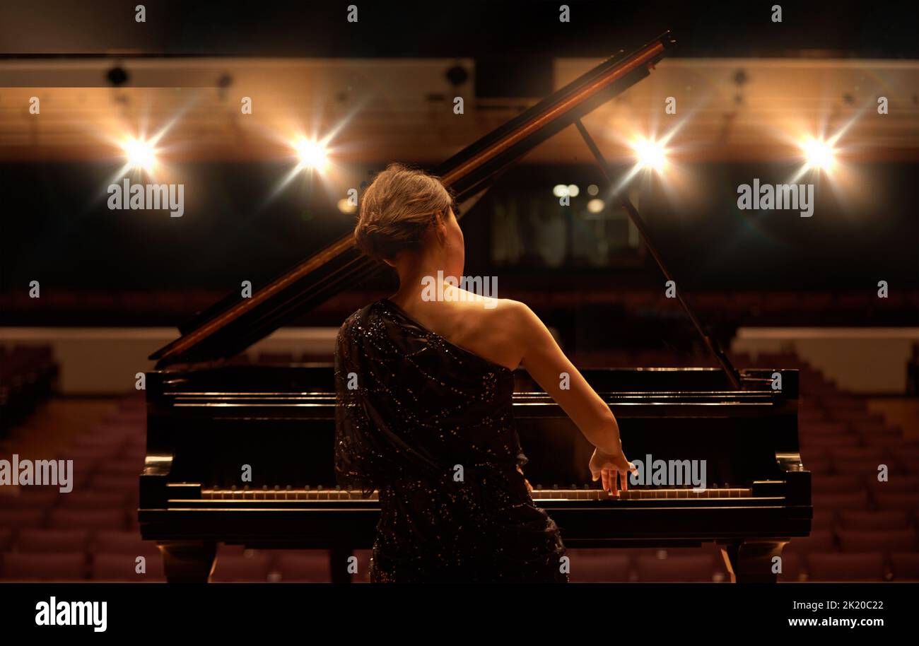 Giving a perfect performance. a young woman playing the piano during a ...