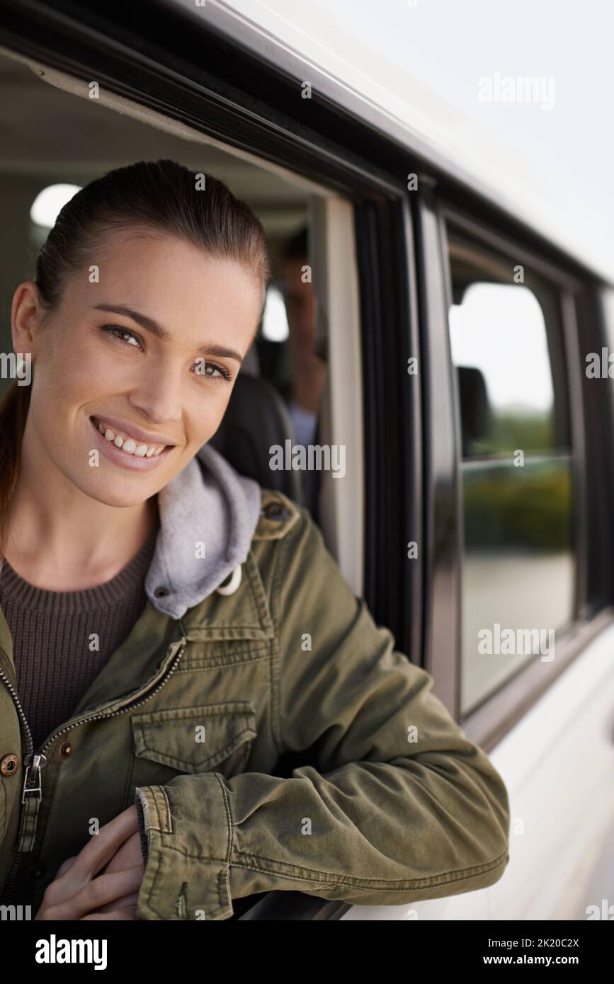 Enjoying The Ride An Attractive Young Woman Looking Through The Car Window While On A Road Trip