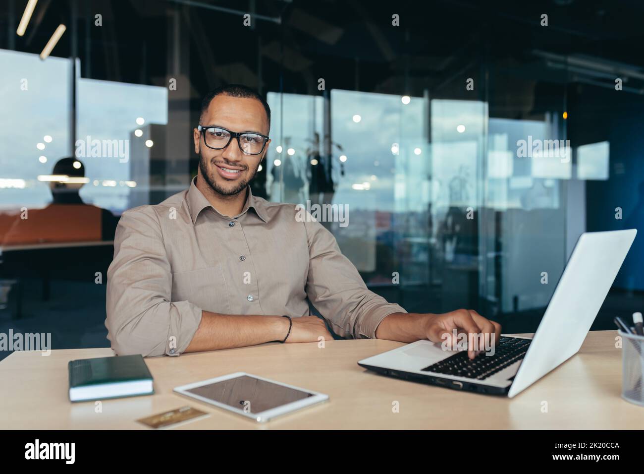 Portrait of successful businessman, man with laptop working inside ...