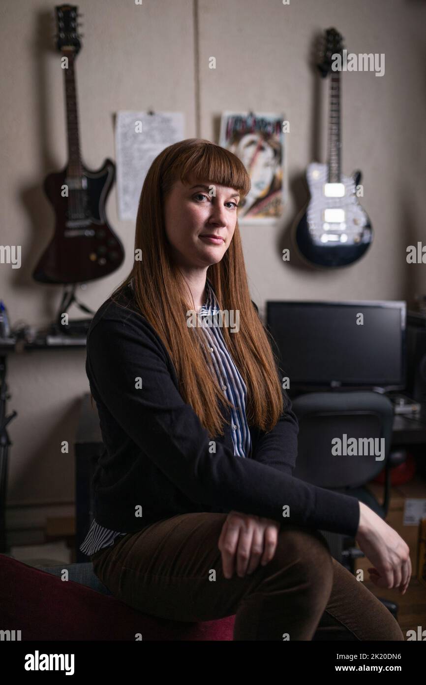 Portrait confident female musician in studio with guitars Stock Photo ...